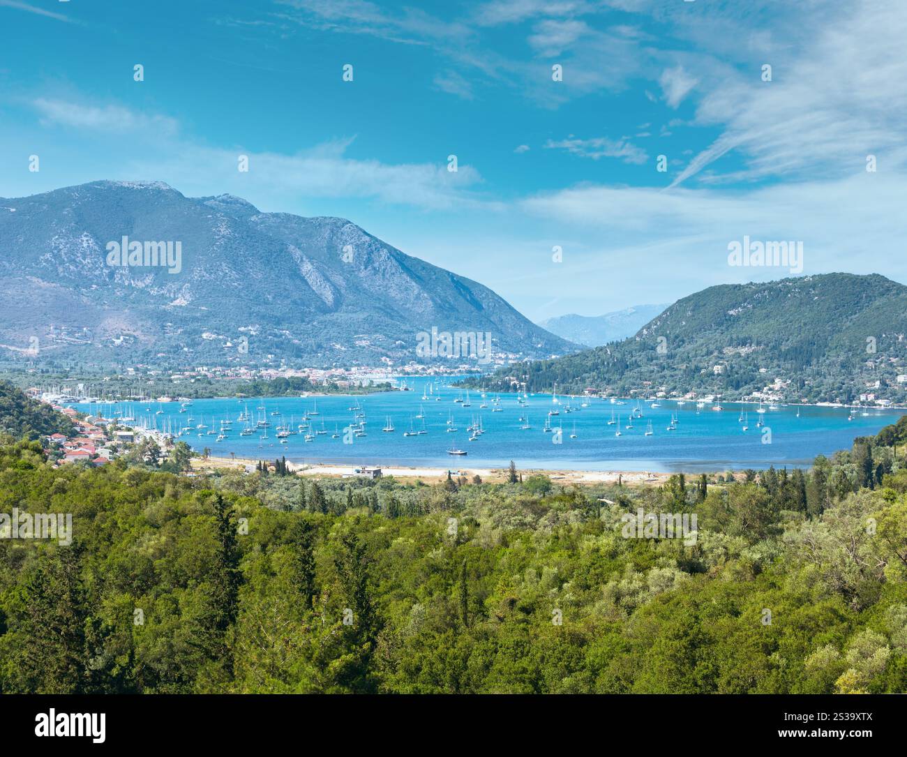 Many sailing vessels in bay. Hazy summer Lefkada coast landscape (Nydri ...