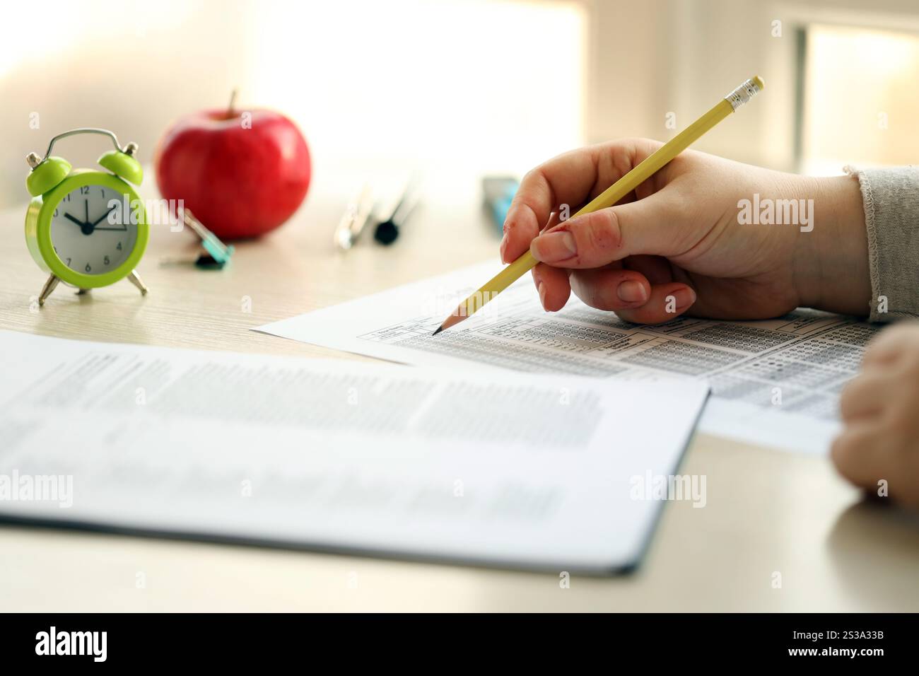 Female student hands testing in exercise and taking fill in exam paper ...