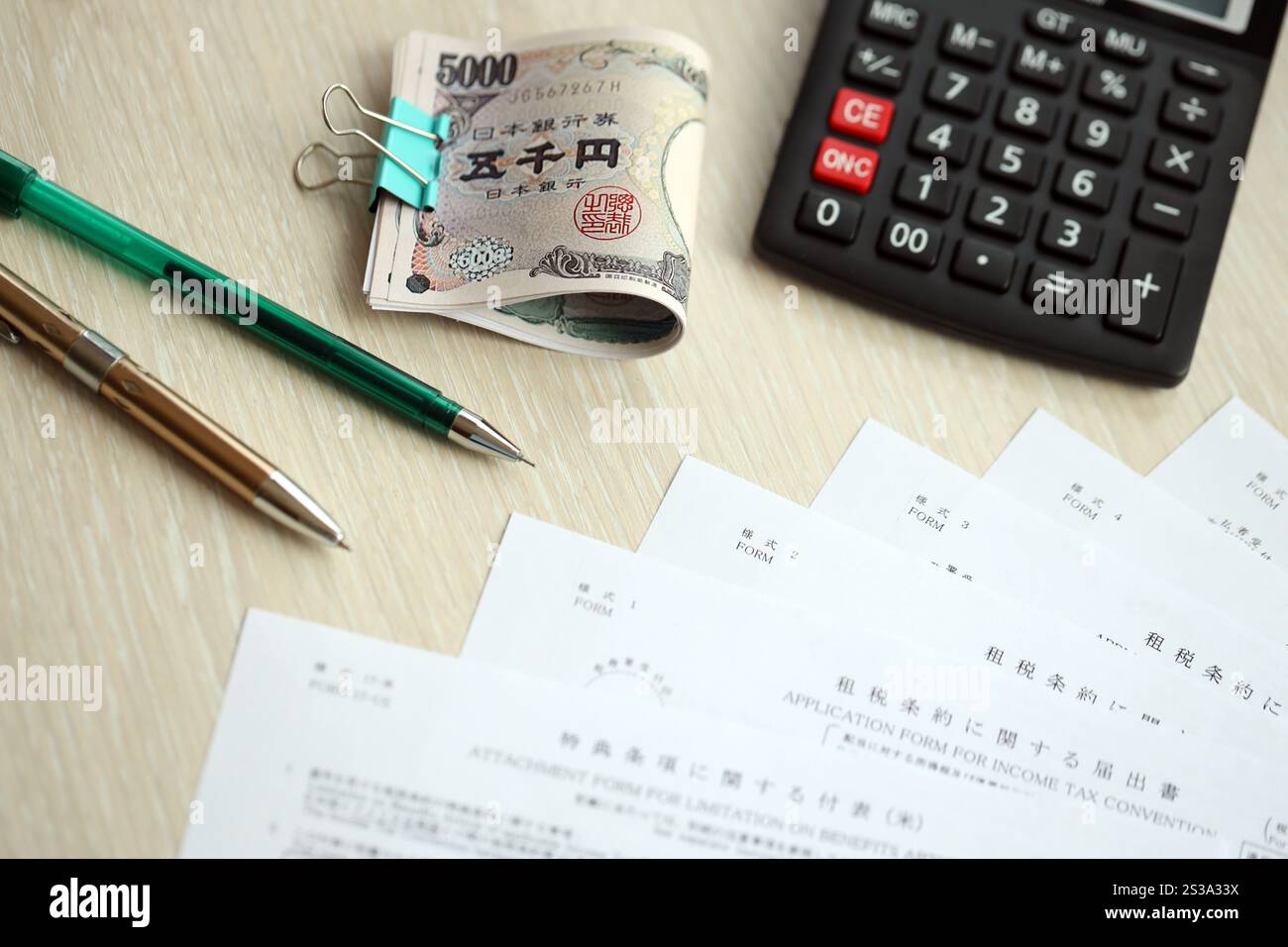 Japanese tax forms lies on table with calculator, pen and japanese yen ...