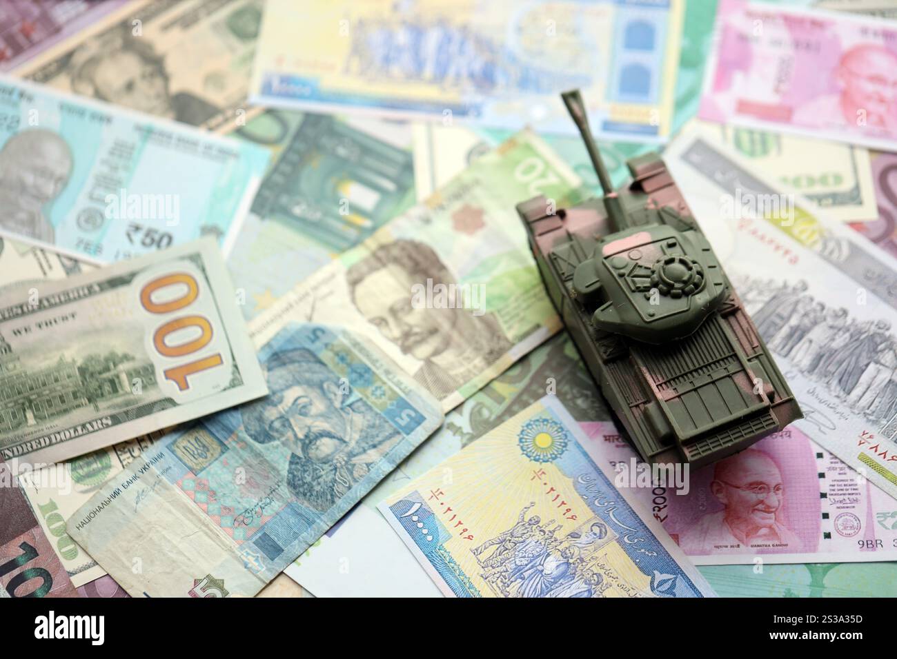 Small green tank on many banknotes of different currency. Background of ...