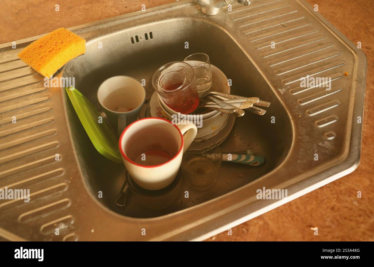 Stack of dirty dishes with food leftovers in the kitchen sink. Unwashed ...