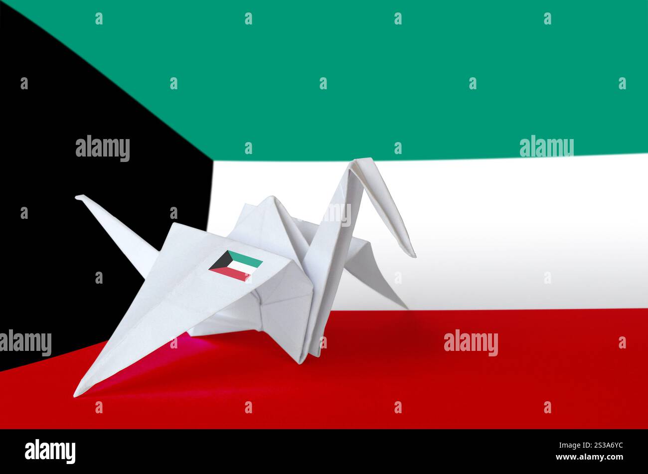 Kuwait flag depicted on paper origami crane wing. Oriental handmade ...