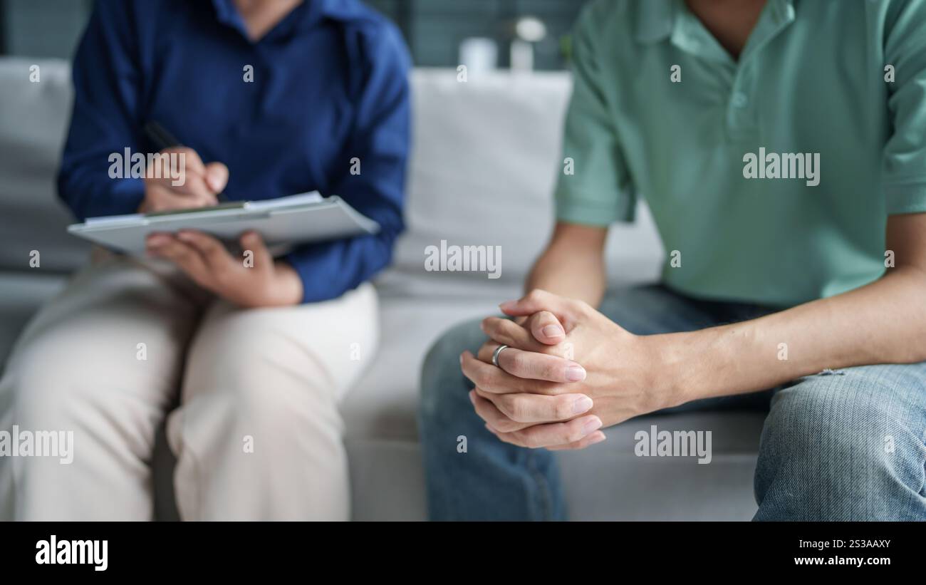 sad male sitting on sofa Patient discussing mental health issues with ...