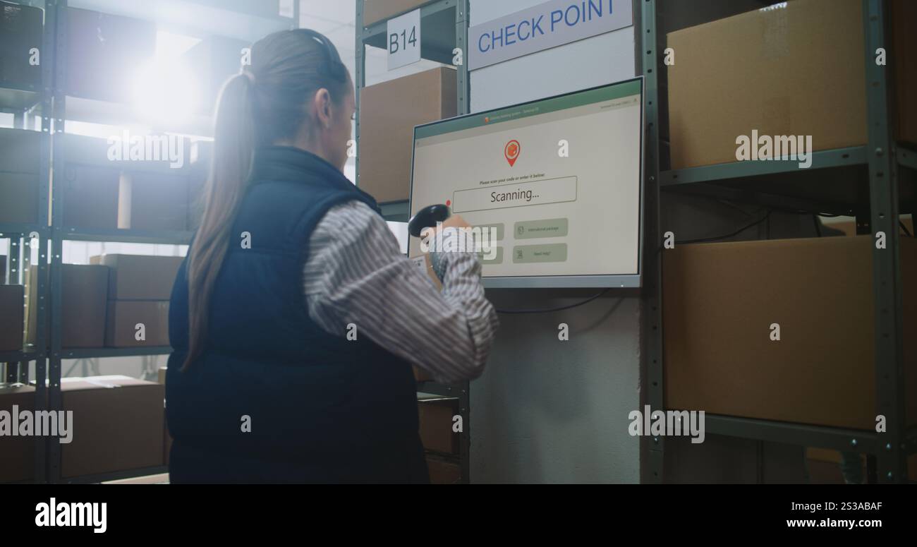 Female Logistics Manager Scans Cardboard Box at Postal Terminal with Digital Screen, Checks ...