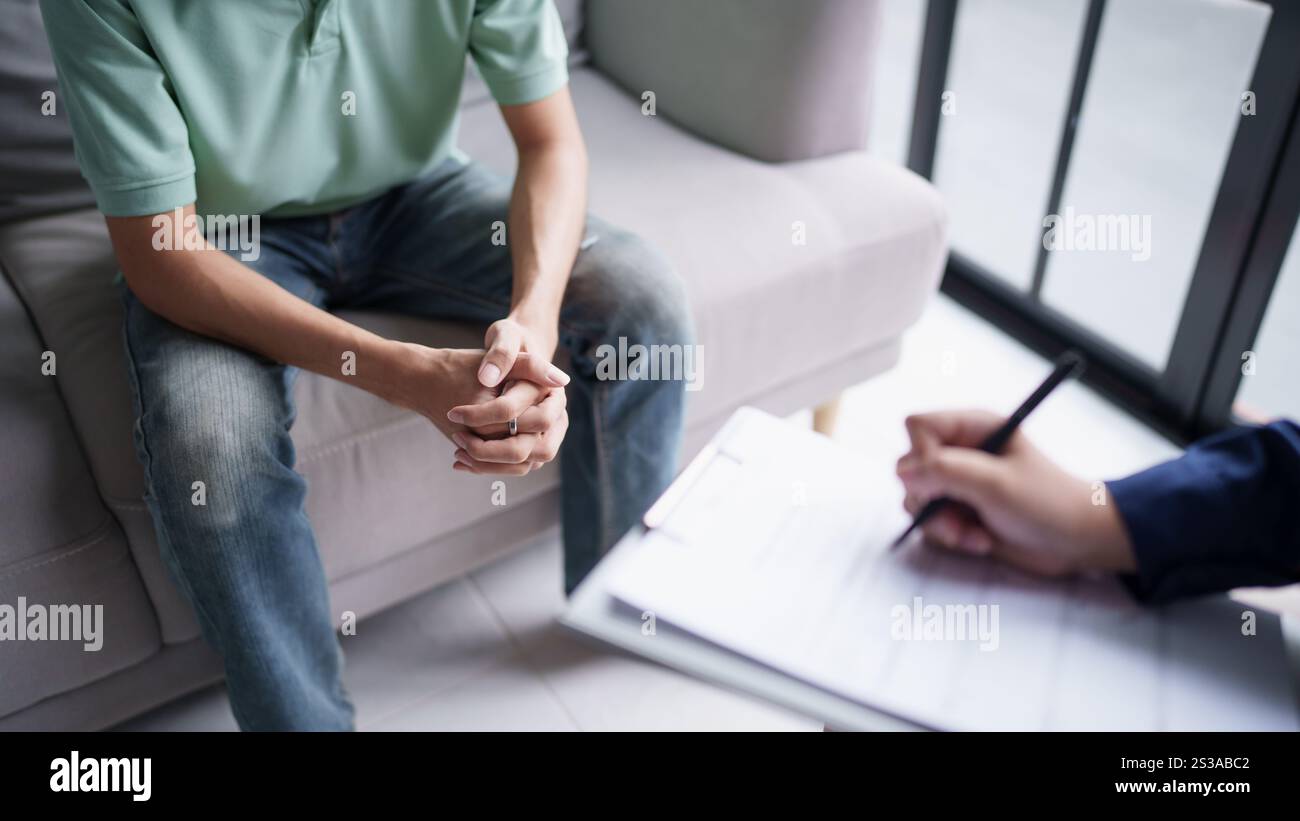 sad male sitting on sofa Patient discussing mental health issues with ...
