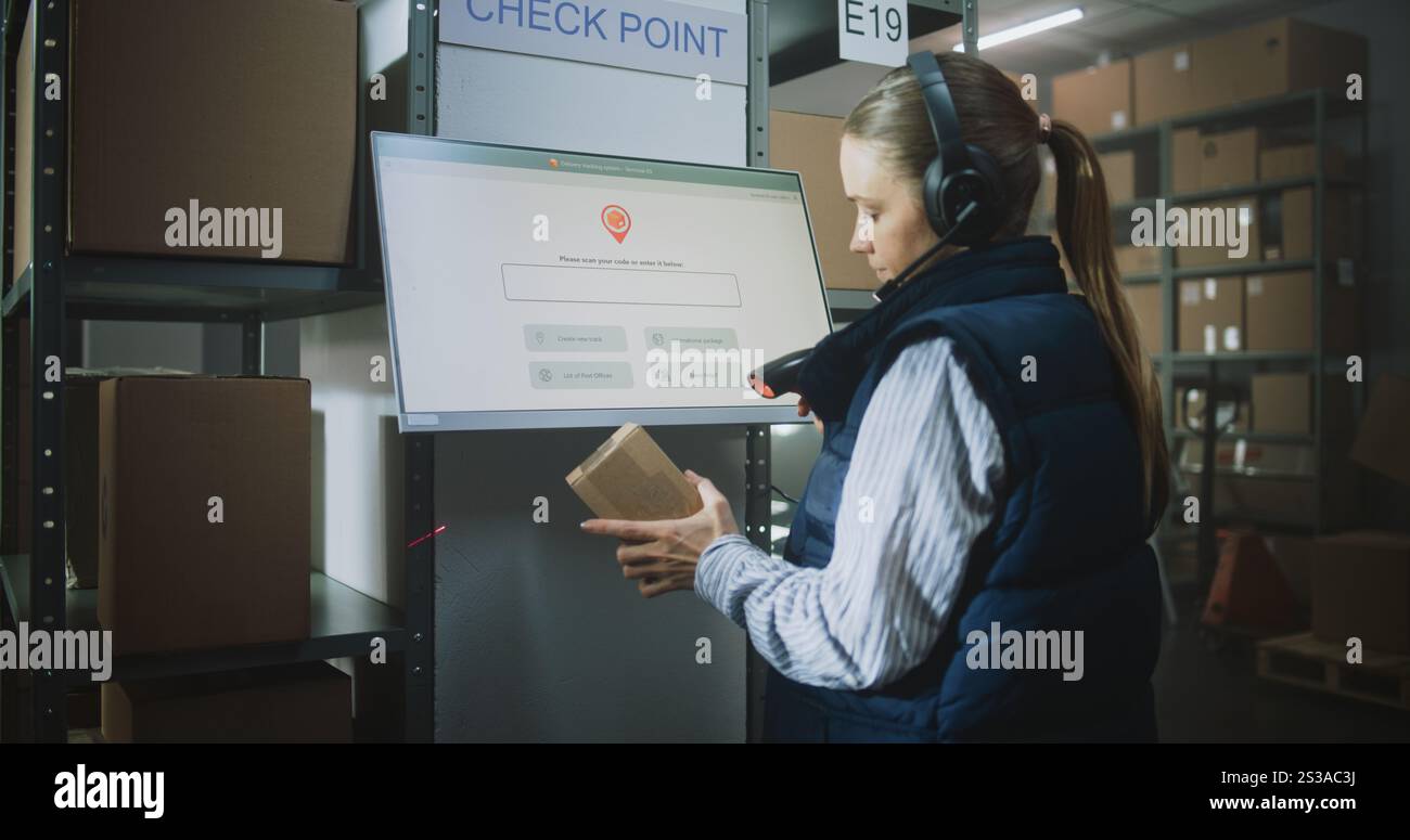 Female Warehouse Employee Wearing Headset Scans Cardboard Box at Postal Terminal with Digital ...