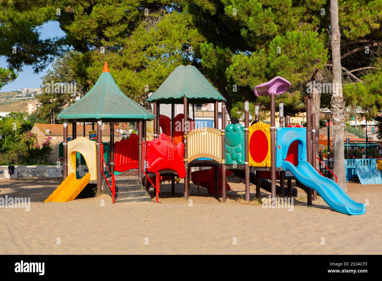 Colorful children's attractions on beach, plastic houses and slides ...