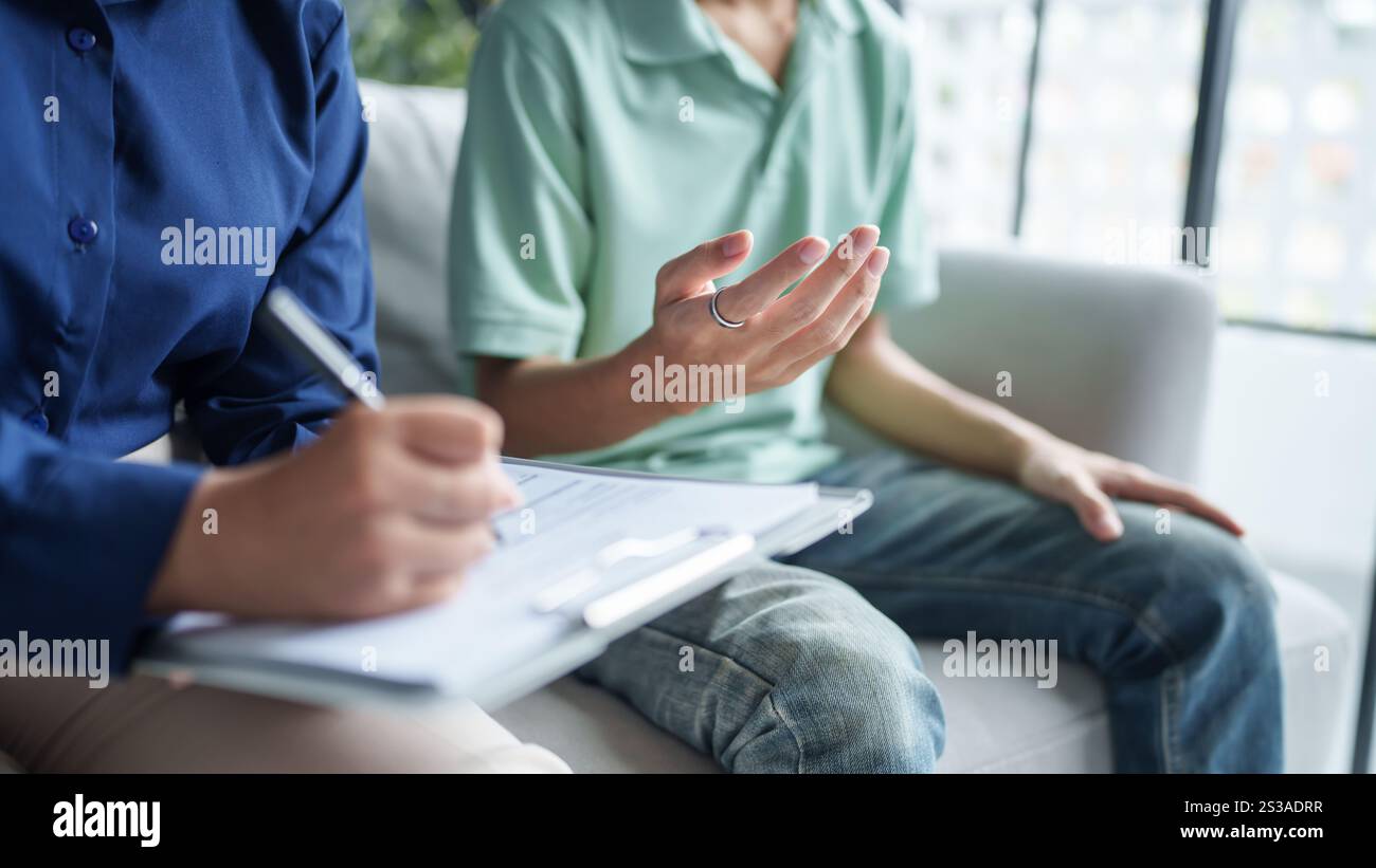 sad male sitting on sofa Patient discussing mental health issues with ...