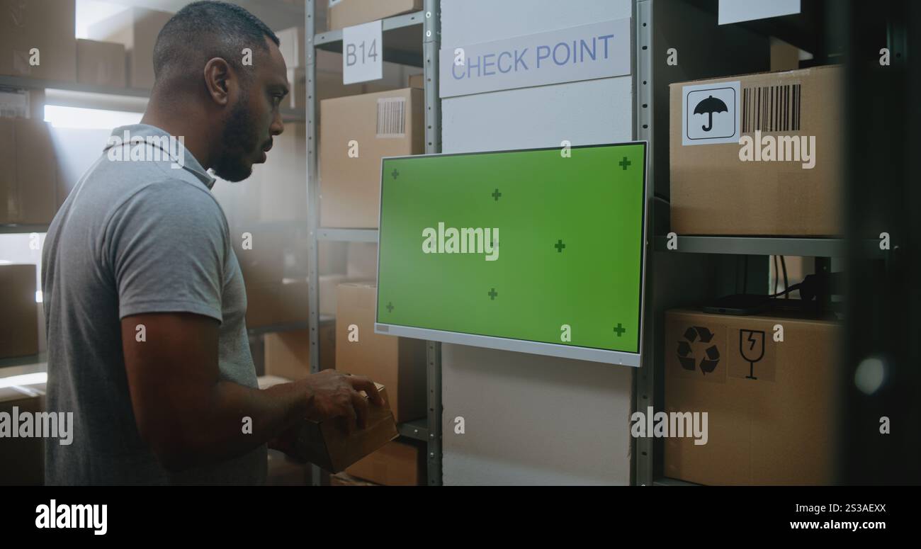African American Warehouse Employee Scans Code on Cardboard Box with Scanner, Checks Package ...