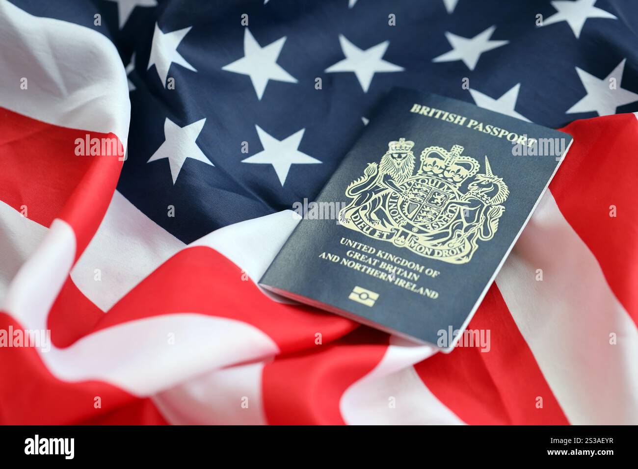 Blue British passport on United States national flag background close ...