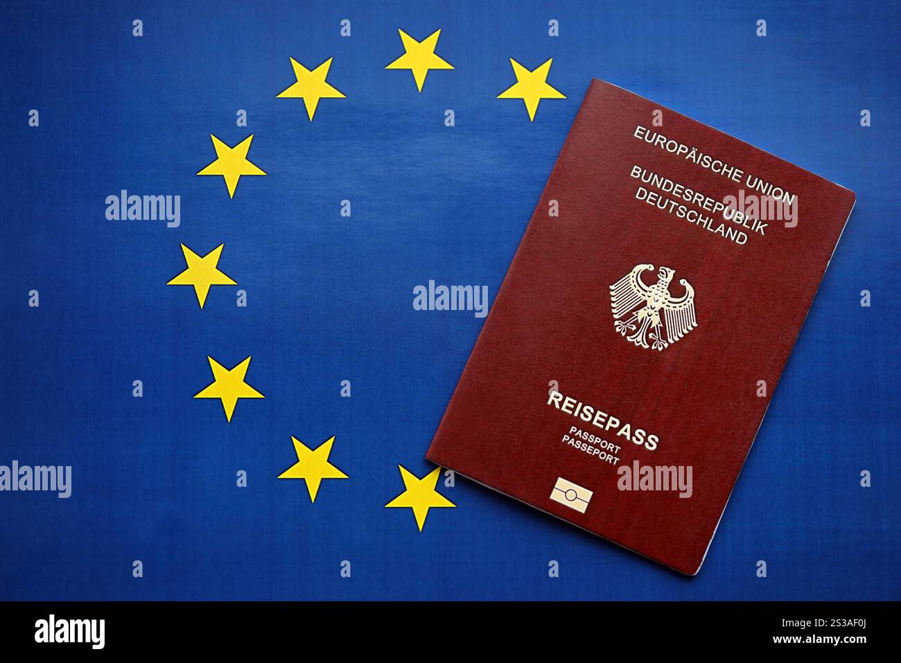 Red German passport of European Union on blue flag background close up ...