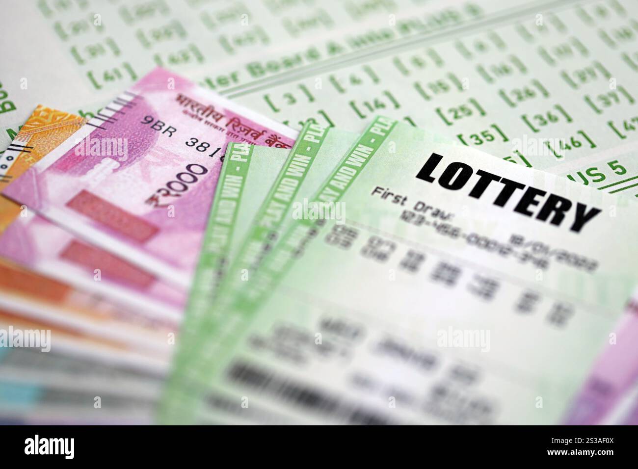 Green lottery tickets and indian rupees money bills on blank with ...
