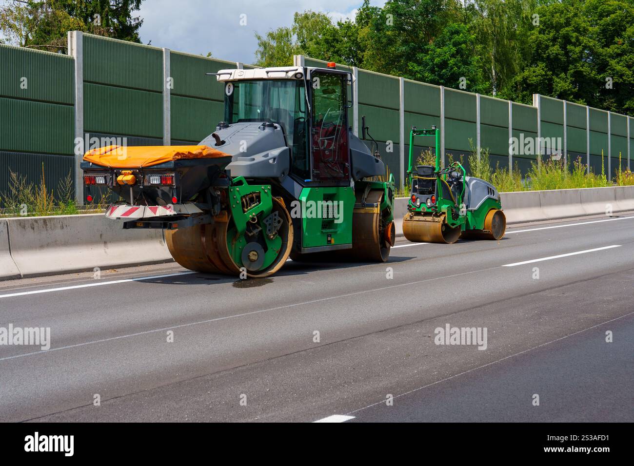 Two Green Road Construction Vehicles Paving New Asphalt on a Highway ...