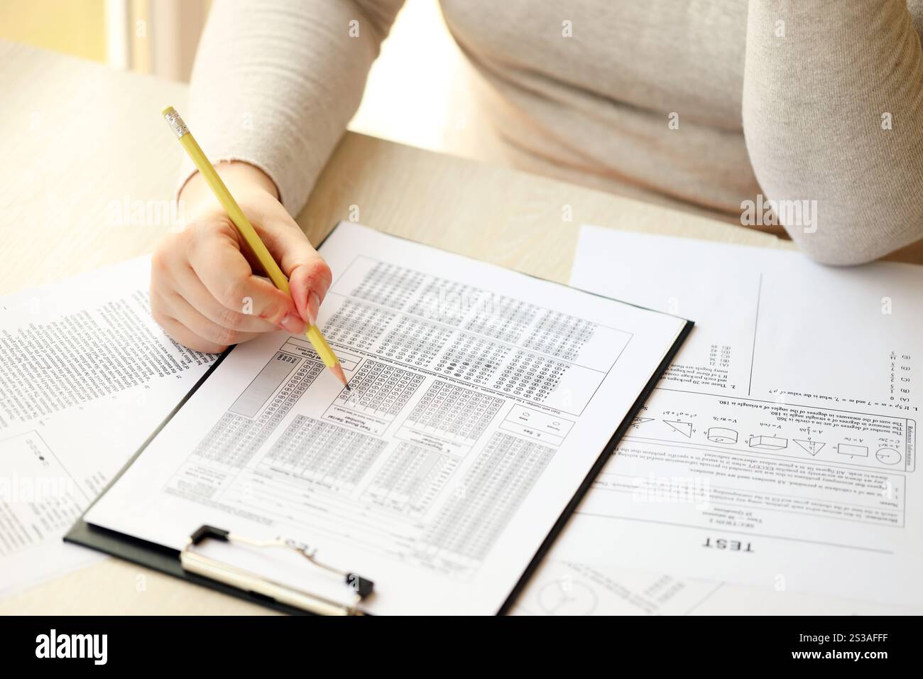 Female student hands testing in exercise and taking fill in exam paper ...