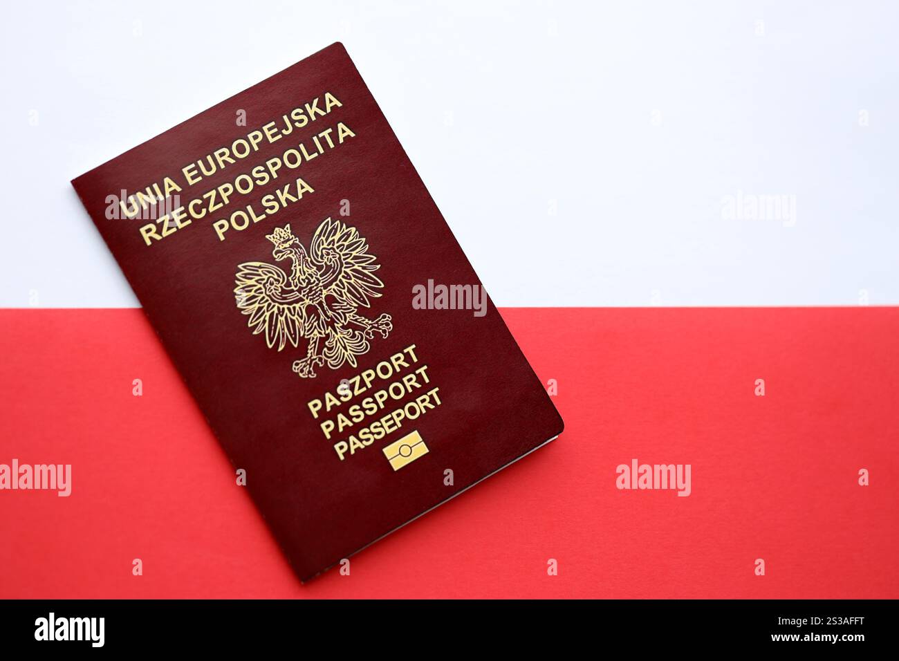 Red polish passport on smooth red and white flag of Poland close up. Red polish passport on ...
