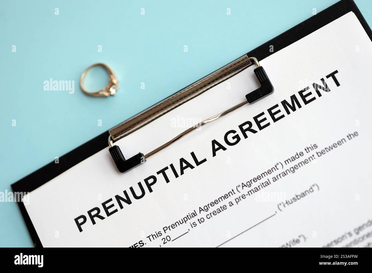 Prenuptial agreement and wedding ring on table. Premarital paperwork ...