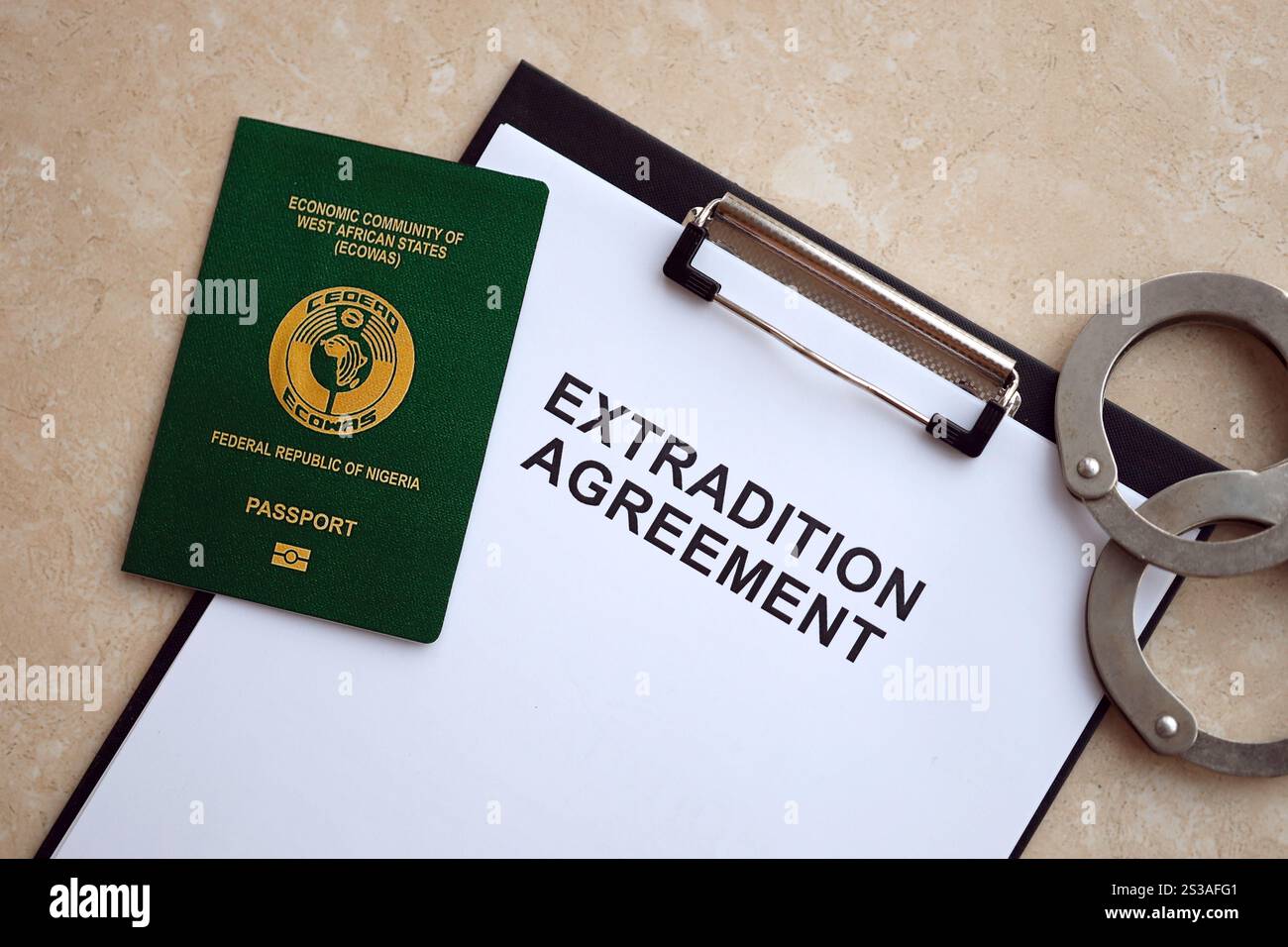 Passport of Pakistan and Extradition Agreement with handcuffs on table ...