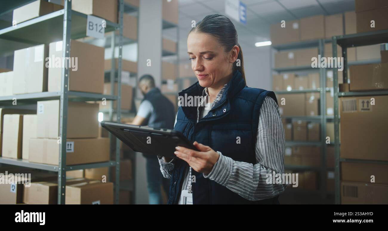 Female Inventory Manager in Warehouse Facility: Uses Tablet Computer ...