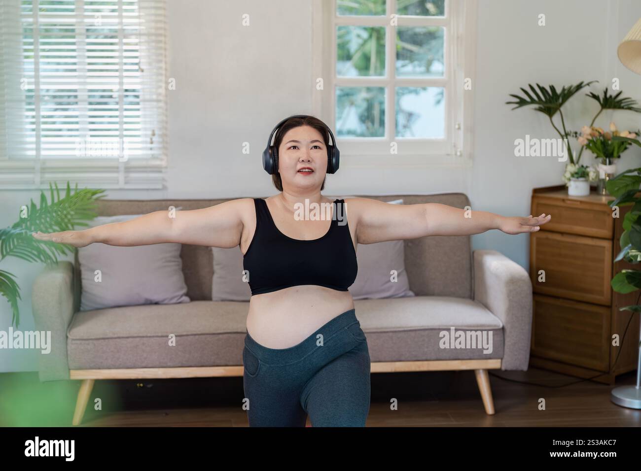 Confident Overweight Woman Exercising at Home with Headphones ...