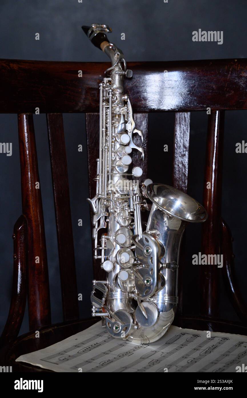 A silver saxophone on an old chair Stock Photo - Alamy