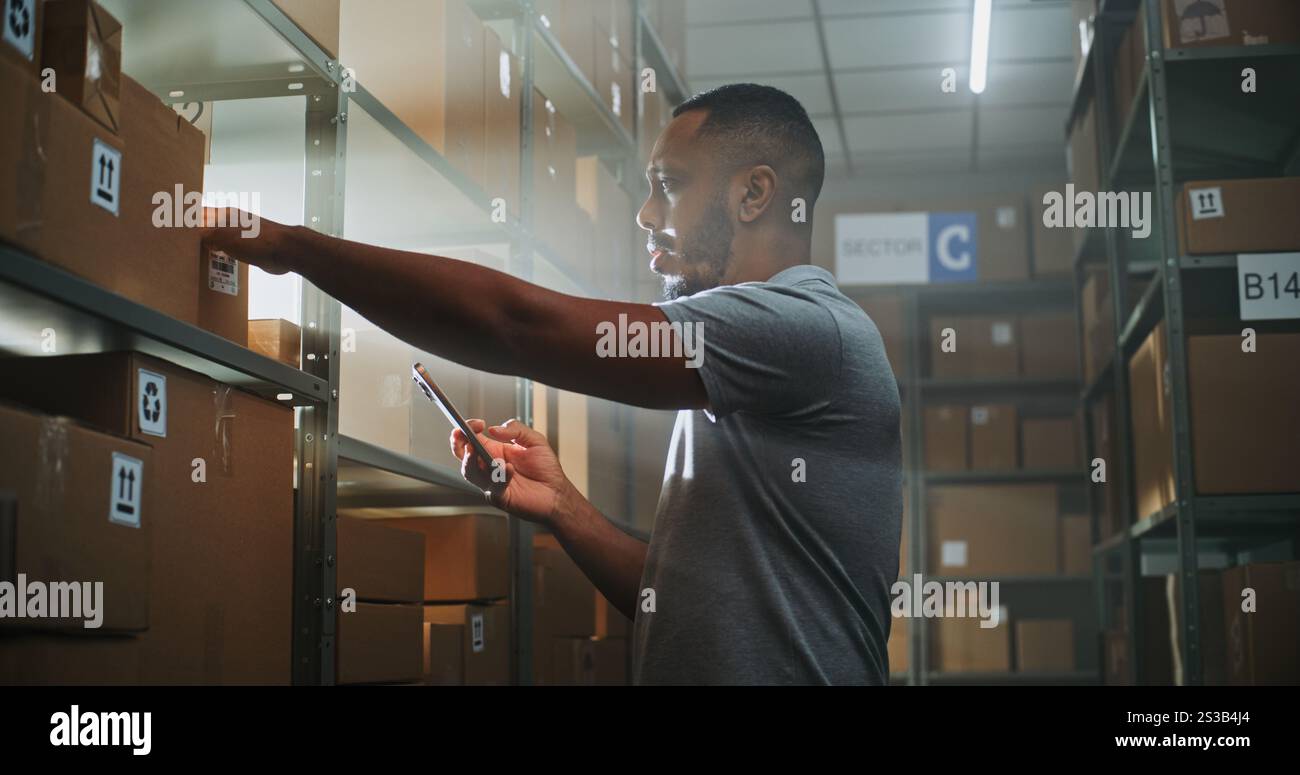 African American Sorting Center Employee Scans Cardboard Box with E-Commerce Order in Warehouse ...