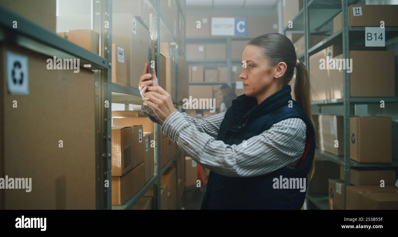 Female Warehouse Associate Scans Cardboard Box with E-Commerce Online Goods Using Smartphone ...