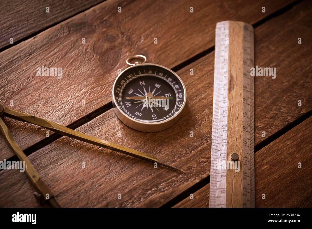 Vintage ruler, drawing and navigational Compass on a rustic wooden ...