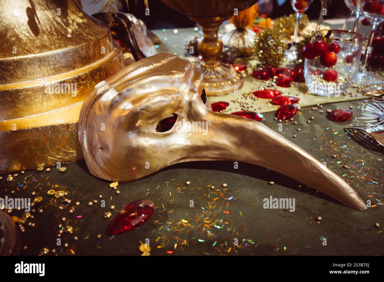 Gold Venetian mask on a table during carnival celebration. Gold ...
