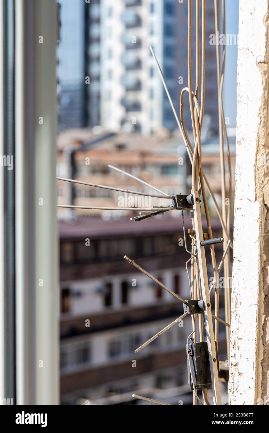 view through open window of residential apartment to old street ...