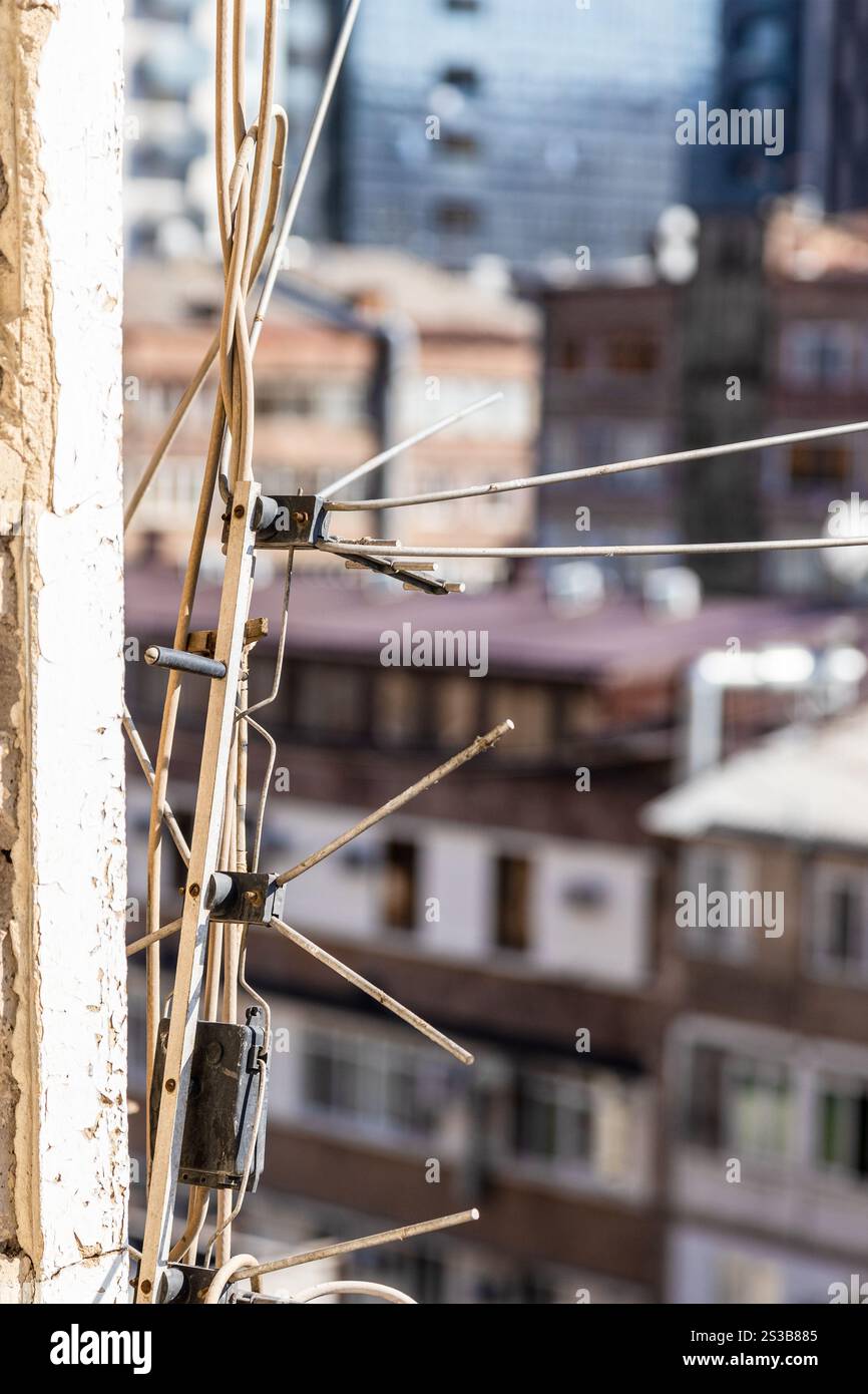 old television and radio antennas on wall of urban house closeup and ...