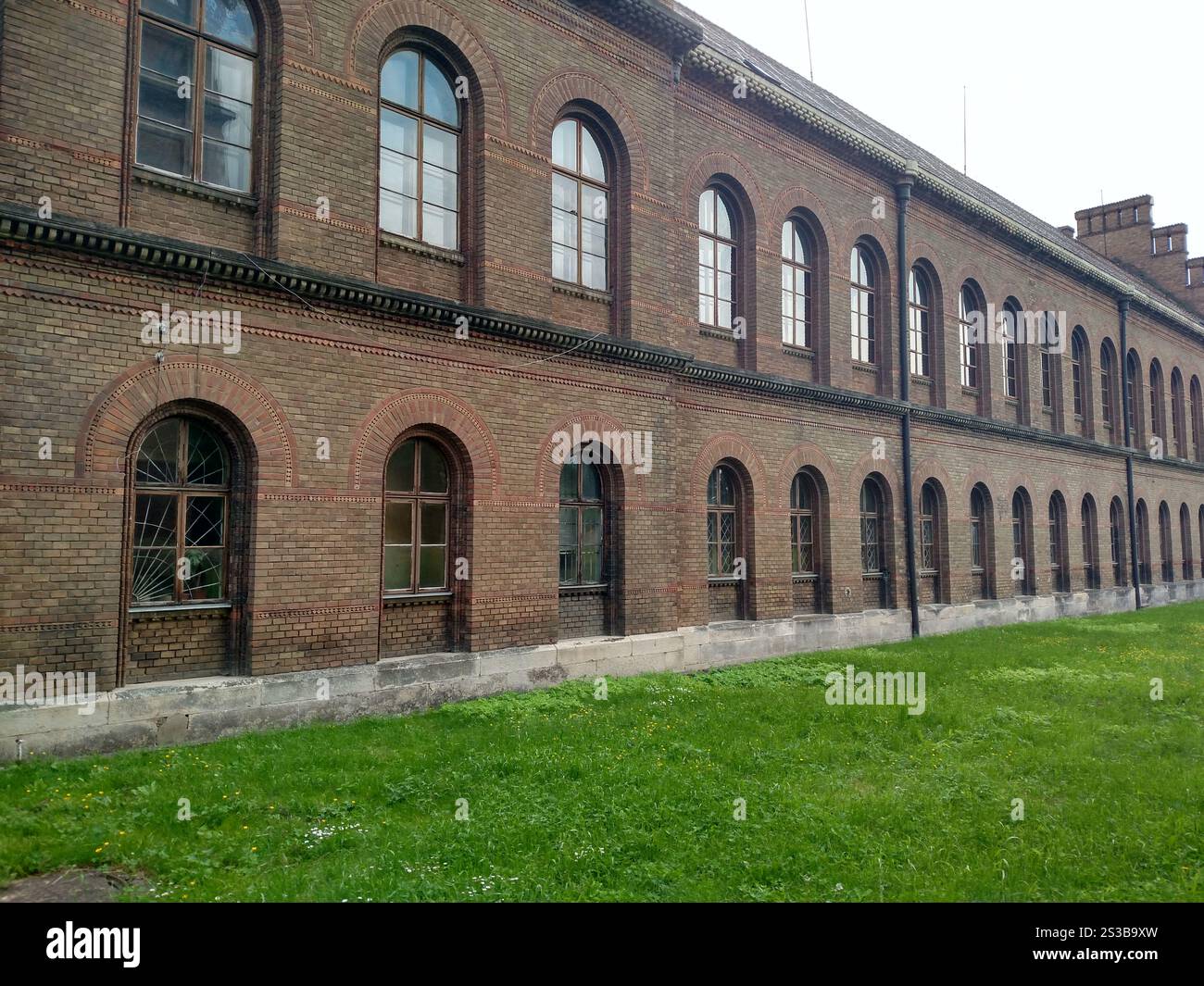 Old building on two floors brick wall grass in front expensive ...