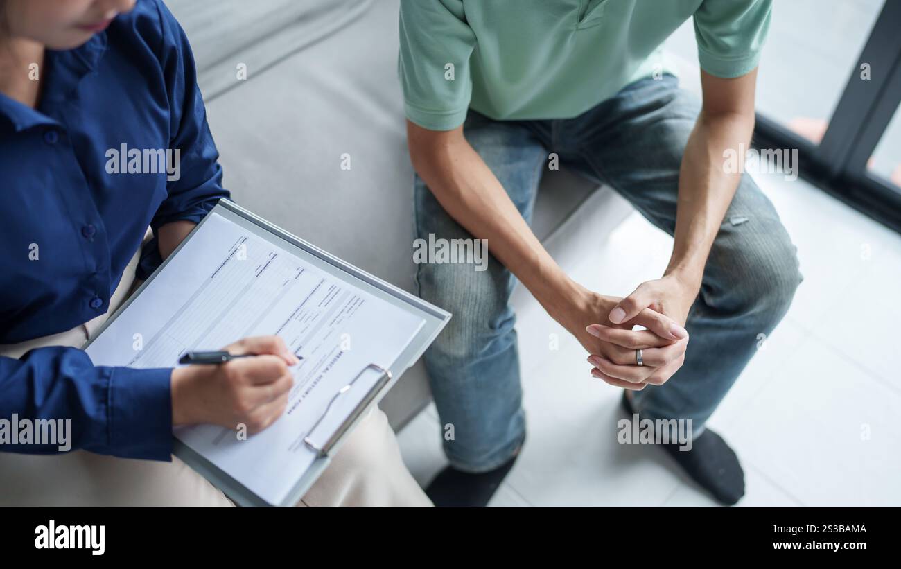 sad male sitting on sofa Patient discussing mental health issues with ...