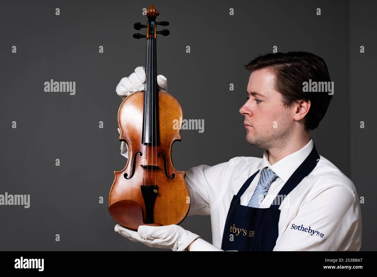A Sotheby's technician holds the Joachim-Ma Stradivarius Violin at Sotheby's in London, ahead of ...