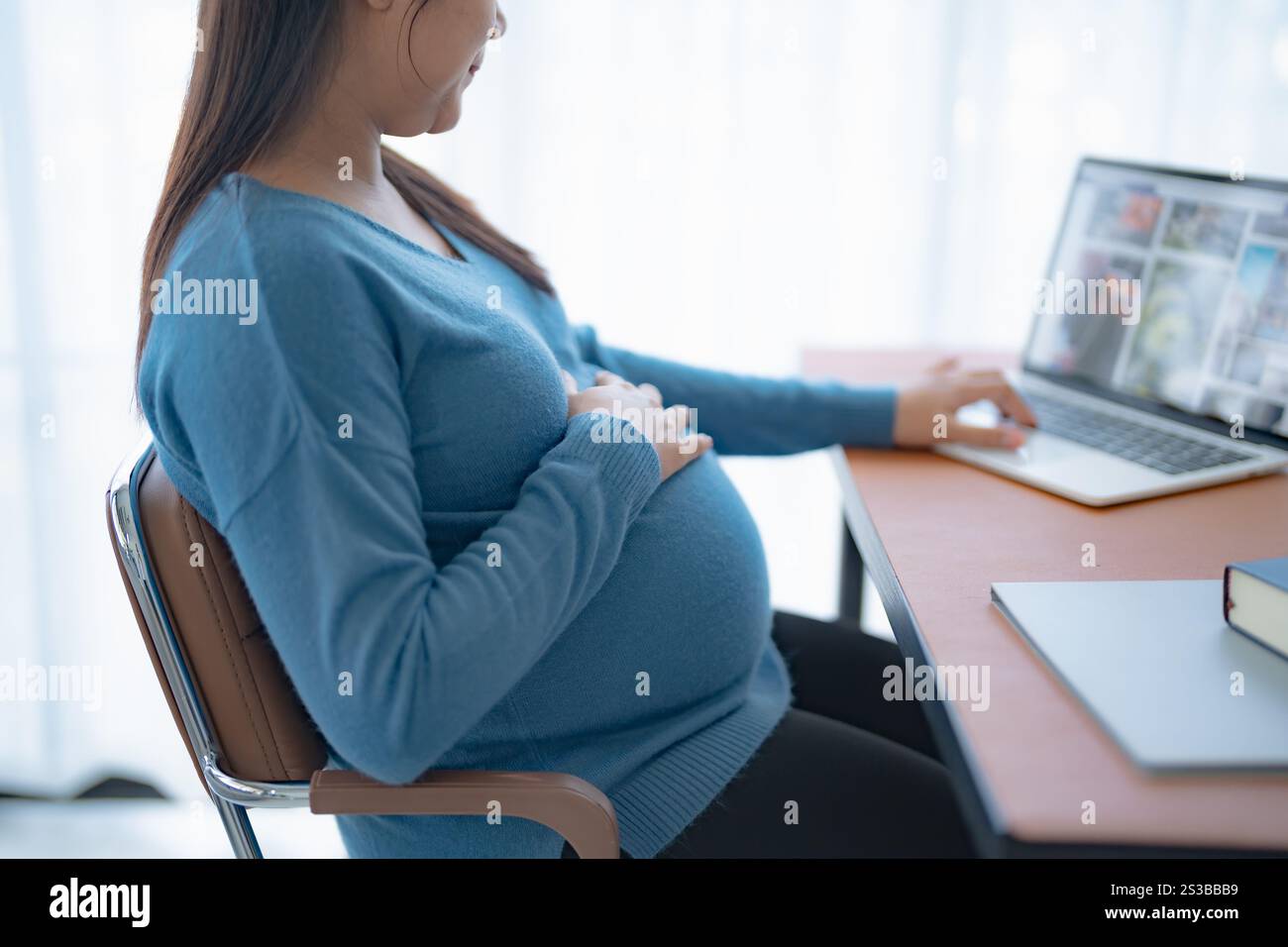 Pregnant asian woman using laptop at home pregnant businesswoman typing ...