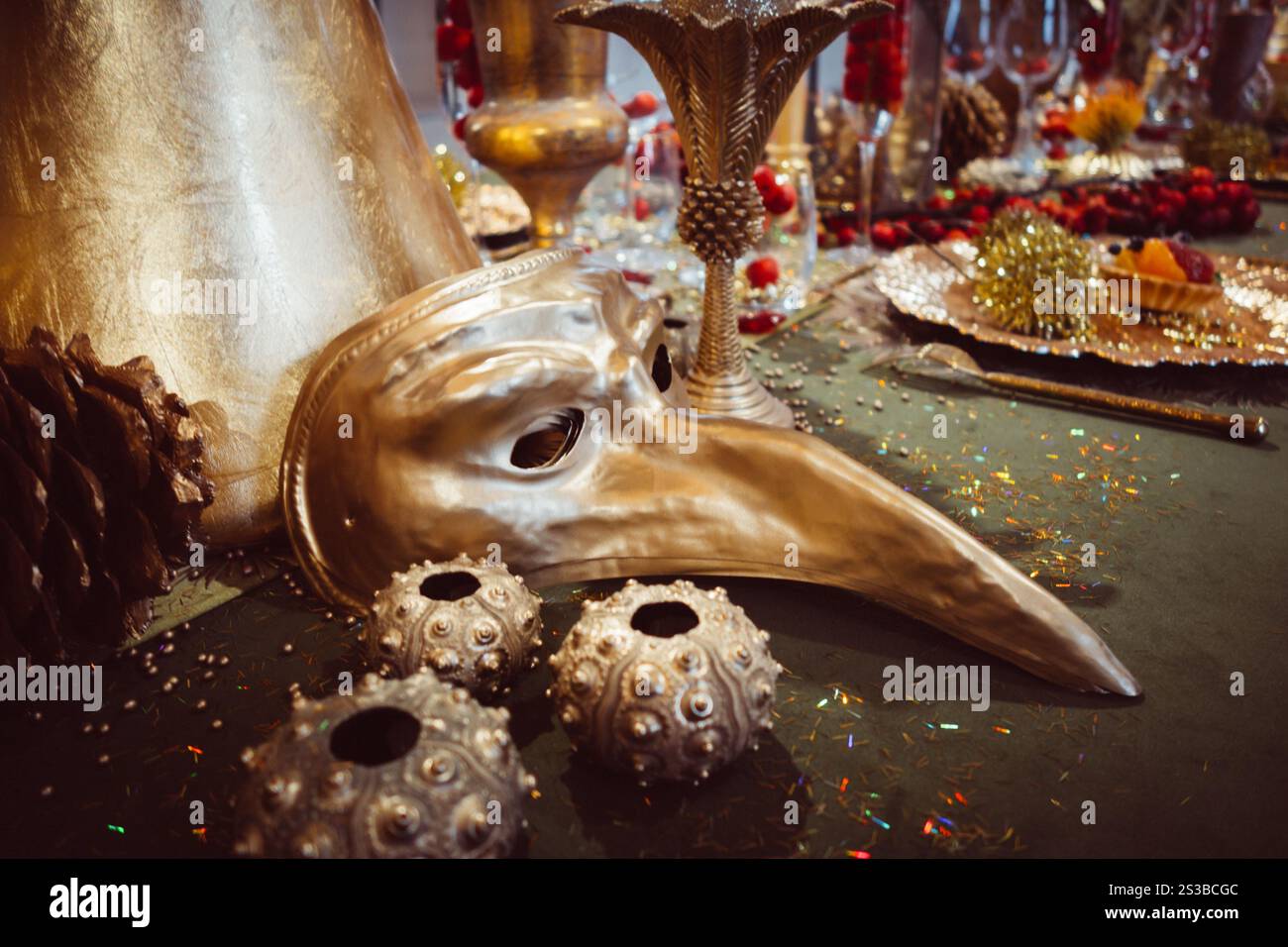 Gold Venetian mask on a table during carnival celebration. Gold ...