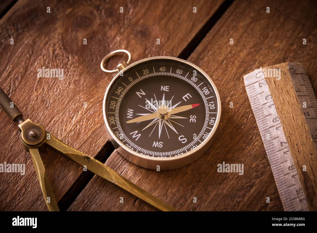 Vintage ruler, drawing and navigational Compass on a rustic wooden ...
