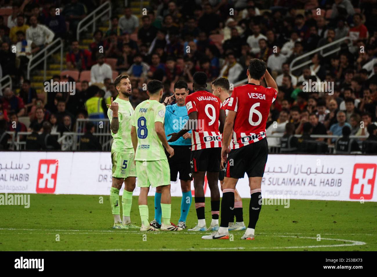 Spanish referee Miguel Ortiz (C) listens to his headset during the ...