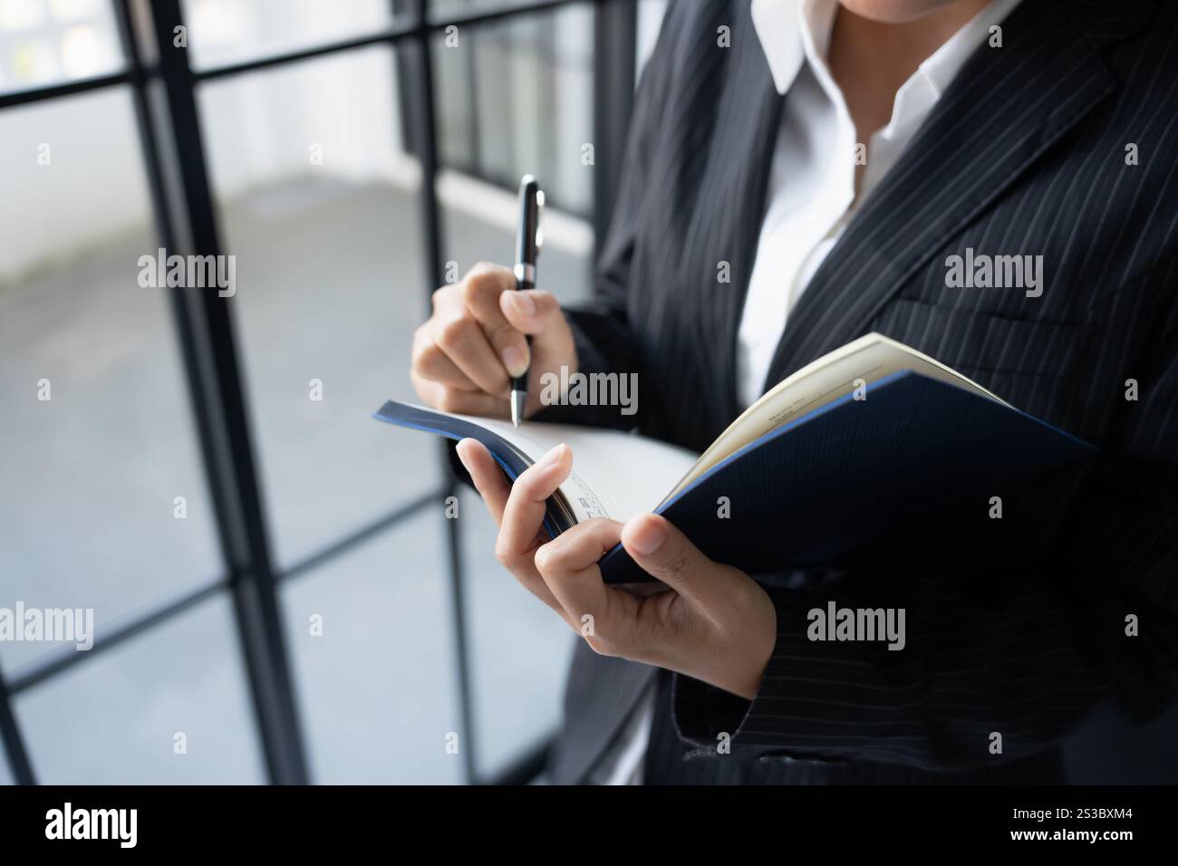 Business woman working from office taking reading and writing notes in ...