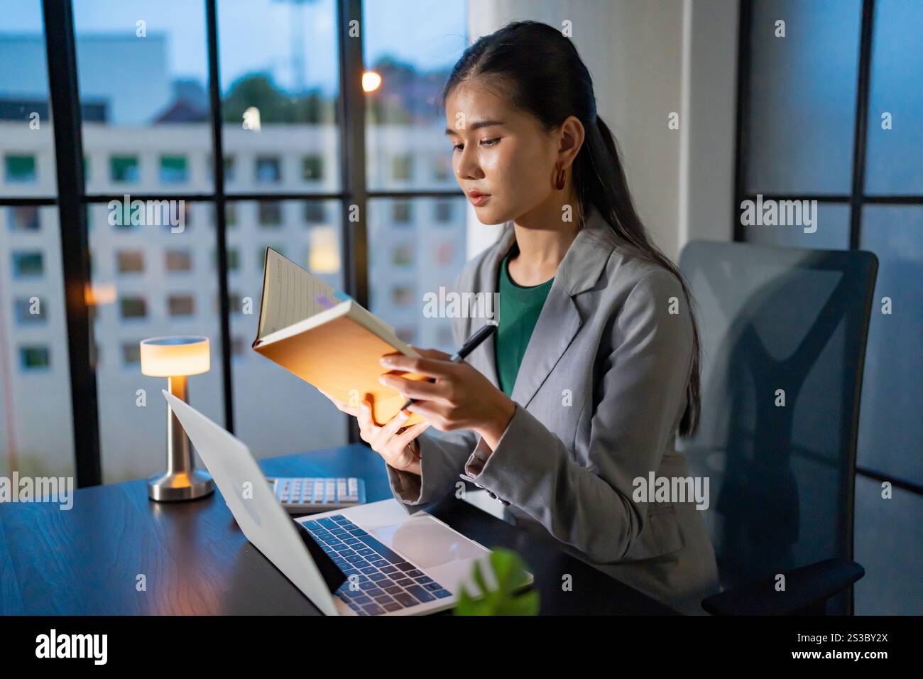 Alone Working Late at Night. Asian business woman at workplace in ...