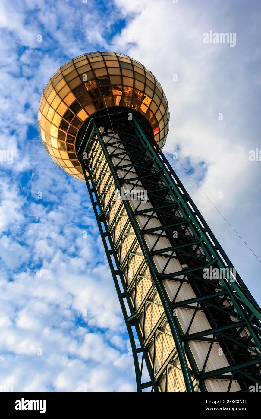 A tall tower with a large golden ball on top. The sky is blue with some ...