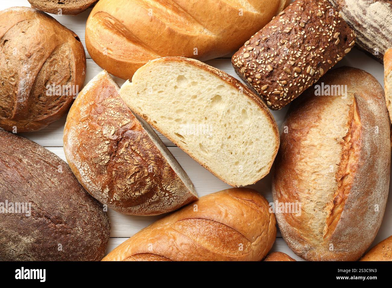 Whole and cut bread loafs on white wooden table, flat lay Stock Photo ...