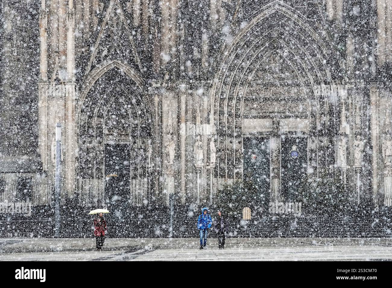 People walk in front of the Cologne Cathedral during heavy snowfall in ...