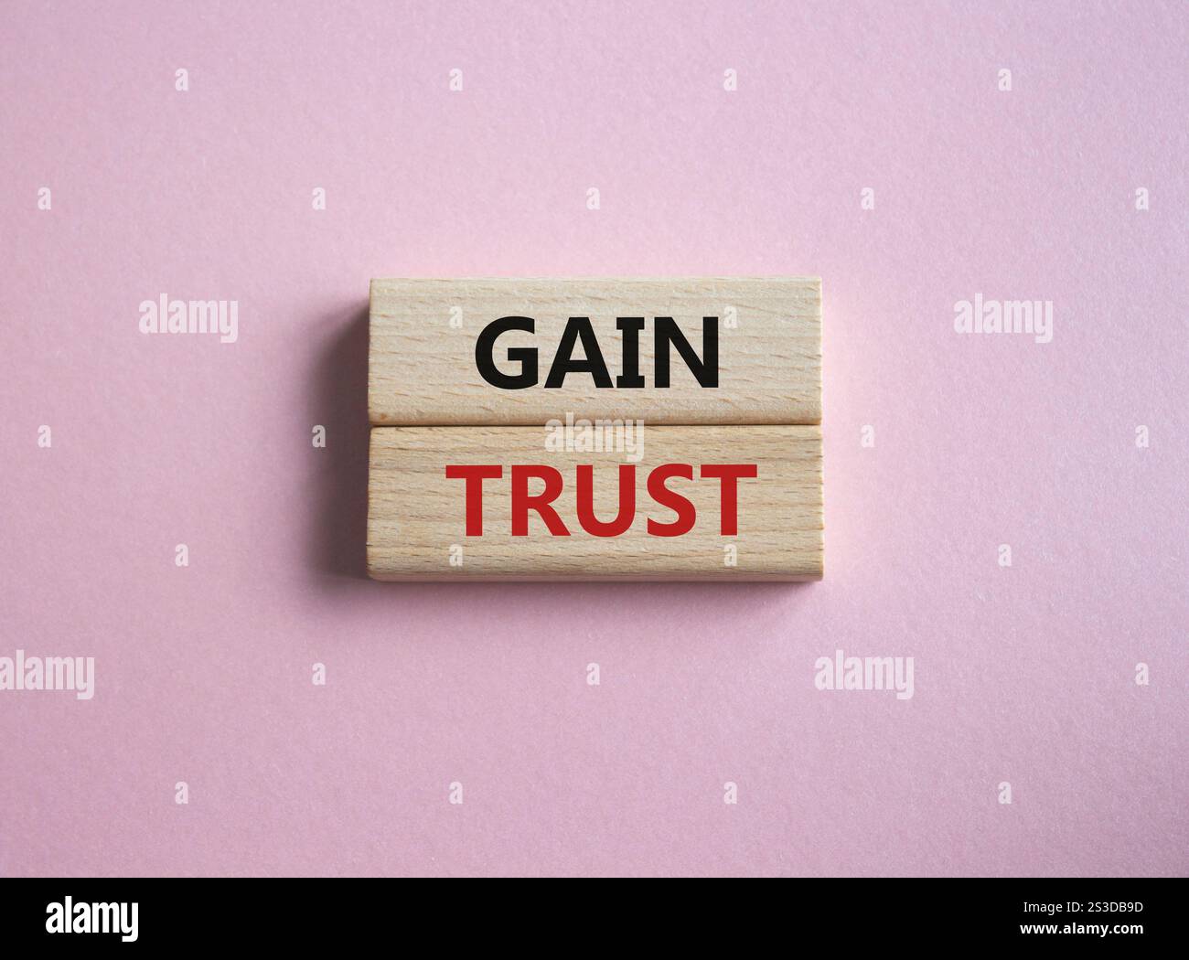 Gain trust symbol. Wooden blocks with words Gain trust. Beautiful pink ...