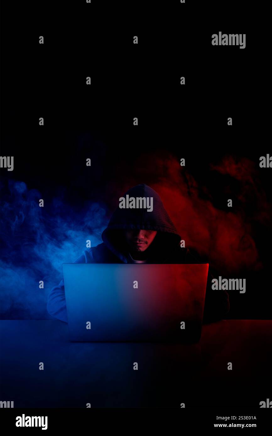 Hooded hacker using a laptop with shield icons symbolizing data ...