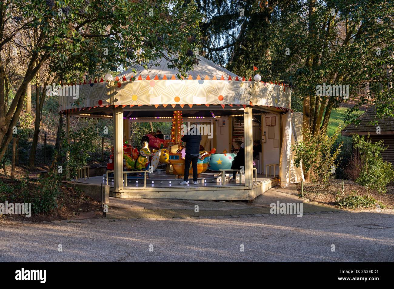 Colorful carousel in Parc des Buttes-Chaumont surrounded by lush ...