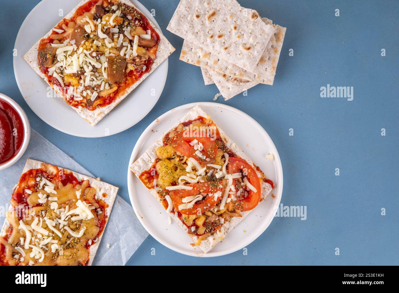 Matzah Pizza on light blue background with ingredients, cheese, tomato ...