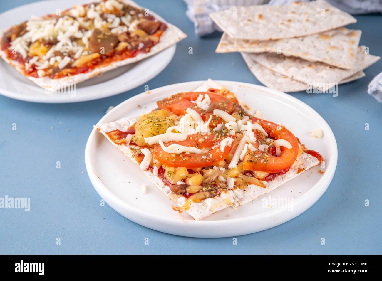 Matzah Pizza on light blue background with ingredients, cheese, tomato ...