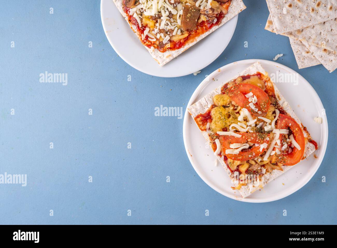 Matzah Pizza on light blue background with ingredients, cheese, tomato ...