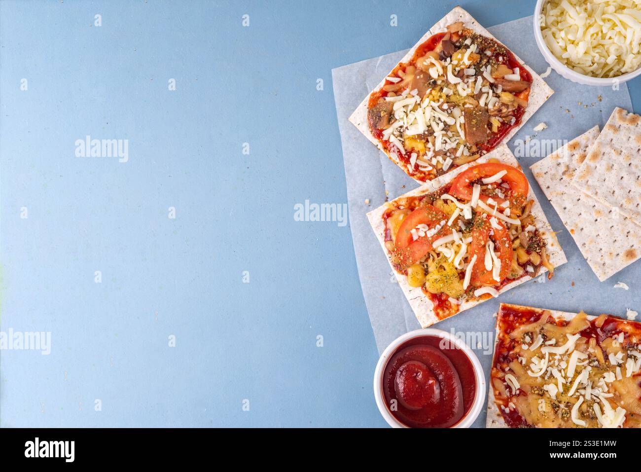 Matzah Pizza on light blue background with ingredients, cheese, tomato ...