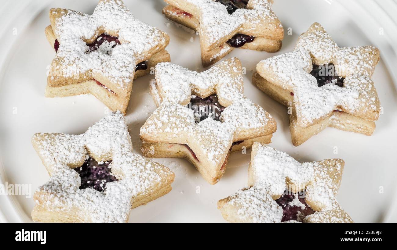 A plate holds star shaped desserts dusted with powdered sugar Stock ...